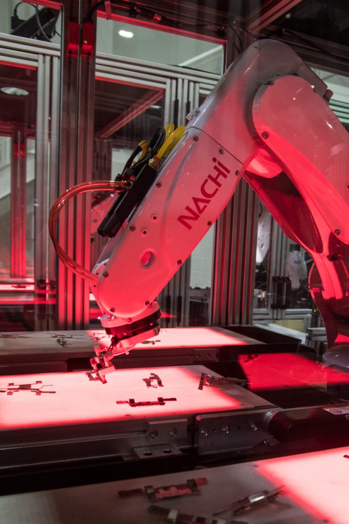 Conveyors with backlighting + robotics automate outlet production